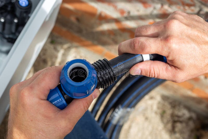 Installation of a Drip Irrigation System for a Garden. a Man Connects a ...