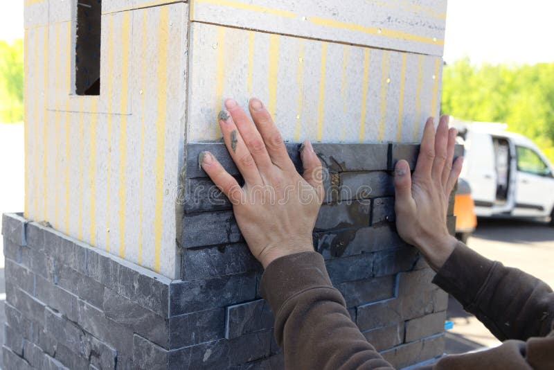 Installation of Facing Tiles on Building Columns is Performed by a ...