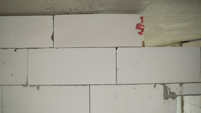 Worker at the Construction Site. Professional Builder Laying Blocks ...