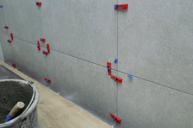 Installation of Porcelain Tiles on the Wall. Tile Leveling System Stock ...