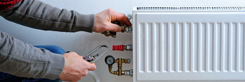 An Installer Working on the Installation of a New Radiator in a ...
