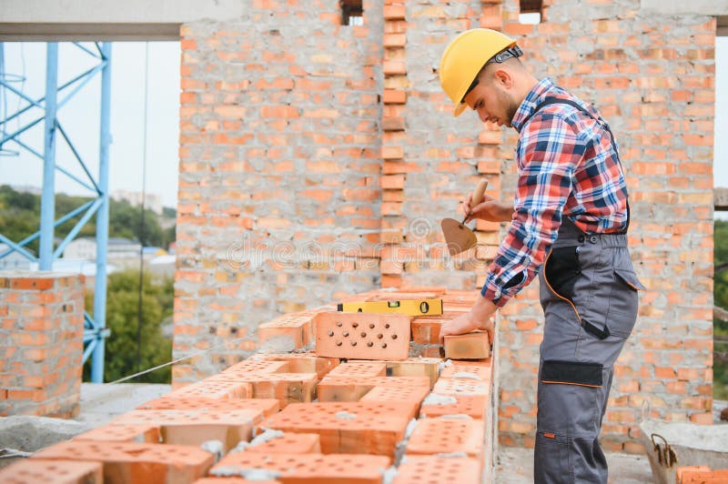Installing Brick Wall. Construction Worker in Uniform and Safety ...