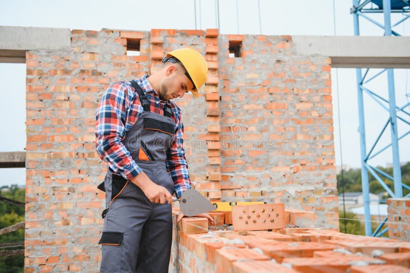 Installing Brick Wall. Construction Worker in Uniform and Safety ...
