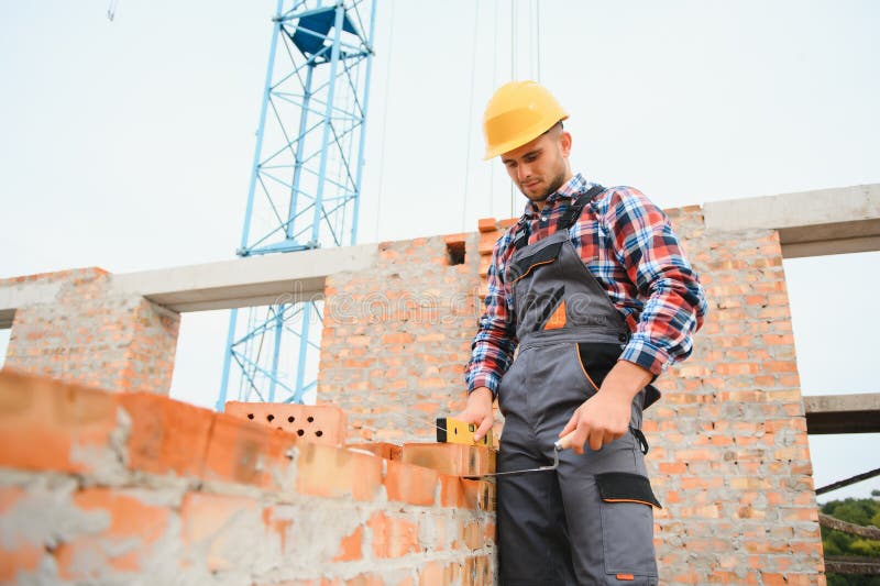 Installing Brick Wall. Construction Worker in Uniform and Safety ...
