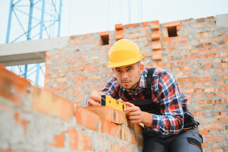 Installing Brick Wall. Construction Worker in Uniform and Safety ...