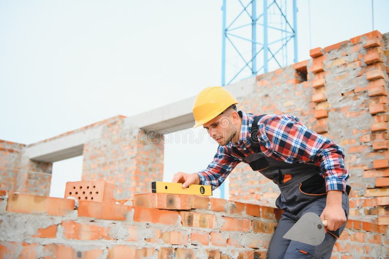 Installing Brick Wall. Construction Worker in Uniform and Safety ...