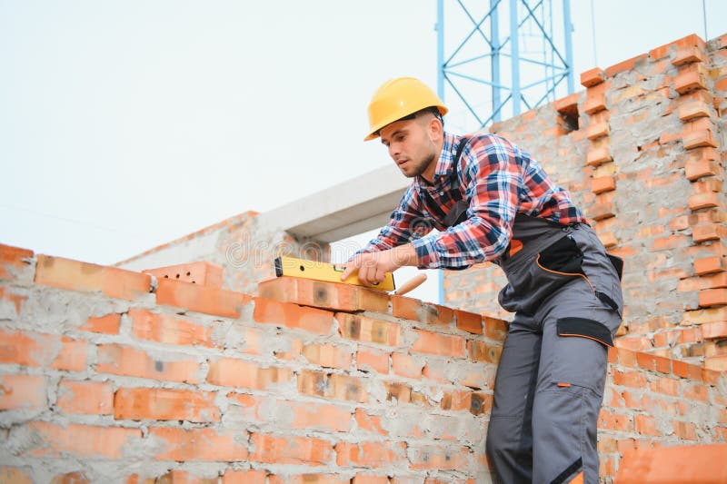 Installing Brick Wall. Construction Worker in Uniform and Safety ...