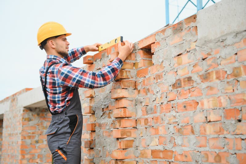 Installing Brick Wall. Construction Worker in Uniform and Safety ...