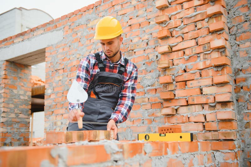 Installing Brick Wall. Construction Worker in Uniform and Safety ...