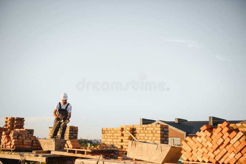 Installing Brick Wall. Construction Worker in Uniform and Safety ...