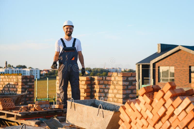 Installing Brick Wall. Construction Worker in Uniform and Safety ...
