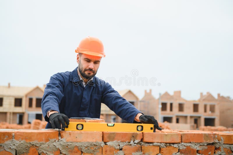 Installing Brick Wall. Construction Worker in Uniform and Safety ...