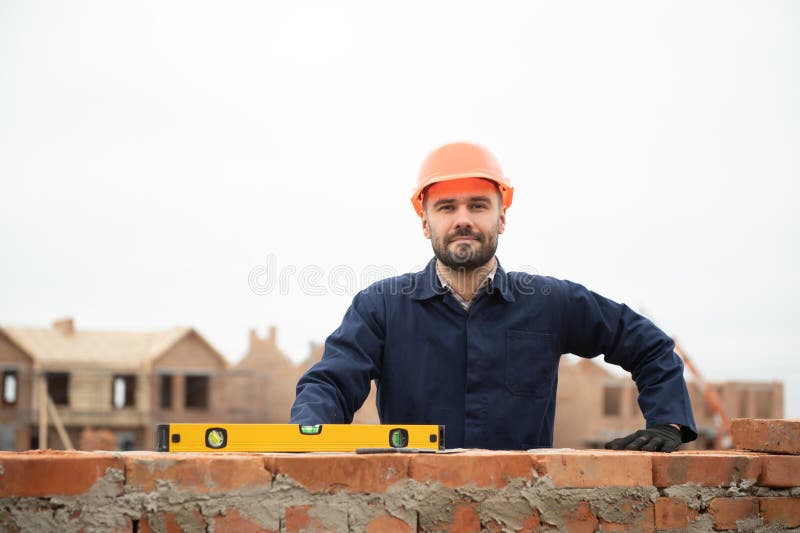 Installing Brick Wall. Construction Worker in Uniform and Safety ...