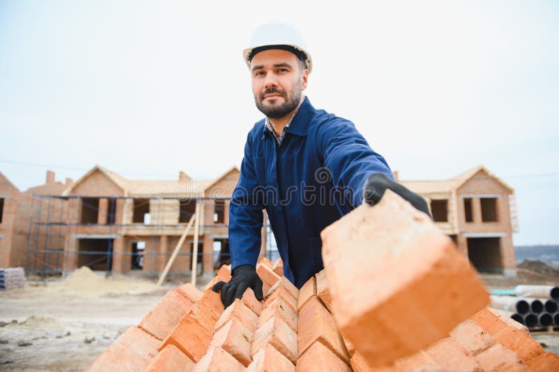 Installing Brick Wall. Construction Worker in Uniform and Safety ...