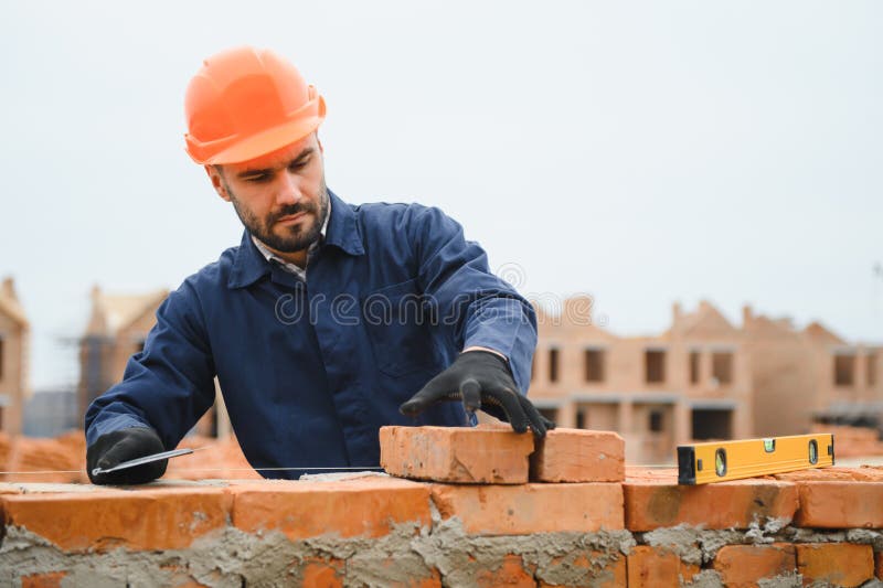 Installing Brick Wall. Construction Worker in Uniform and Safety ...