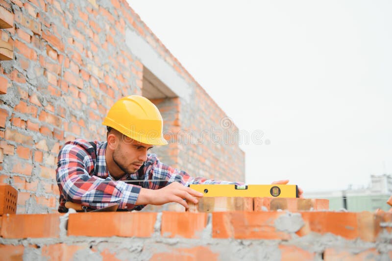 Installing Brick Wall. Construction Worker in Uniform and Safety ...