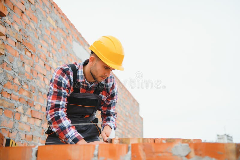 Installing Brick Wall. Construction Worker in Uniform and Safety ...