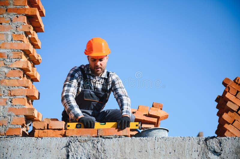 Installing Brick Wall. Construction Worker in Uniform and Safety ...