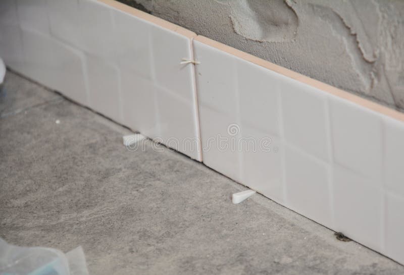 Installing Ceramic Tiles on Bathroom Wall. Close Up on Ceramic Tiles ...