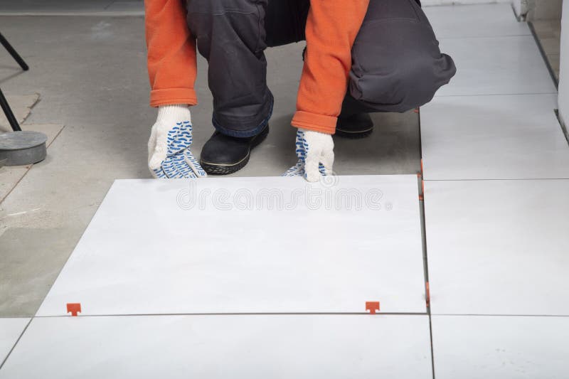 Installing Ceramic Tiles on the Floor. a Worker Installs Ceramic Tiles ...