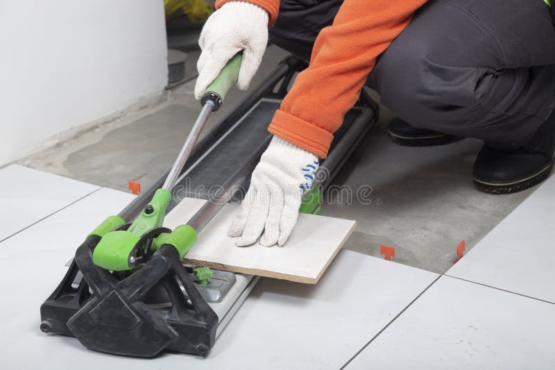 Installing Ceramic Tiles on the Floor. a Worker Installs Ceramic Tiles ...