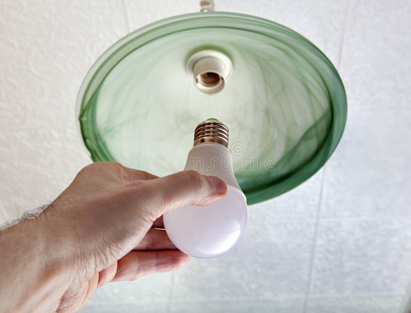 Installing LED Light Bulb in Ceiling Light, Hand Holding Lamp. Stock ...