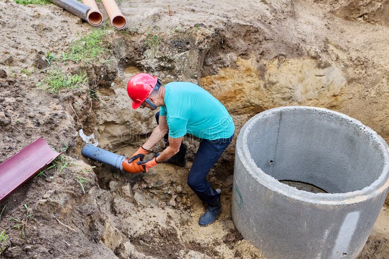Plumber Inserts Bent Fitting into Socket of an Underground Sewer Inlet ...
