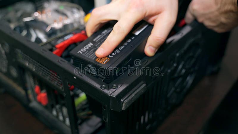 Installing the Power Supply in the System Unit Case. Hands of a Man ...
