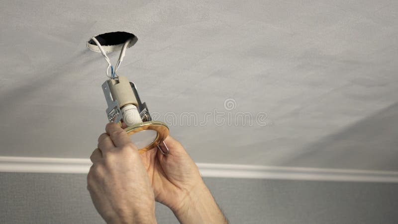 Installing Spot Light, Hand Inserts the Lamp into the Ceiling, Close-up ...