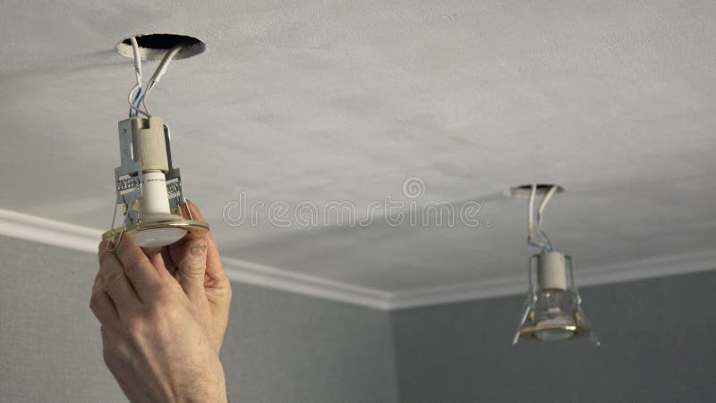 Installing Spot Light, Hand Inserts the Lamp into the Ceiling, Close-up ...