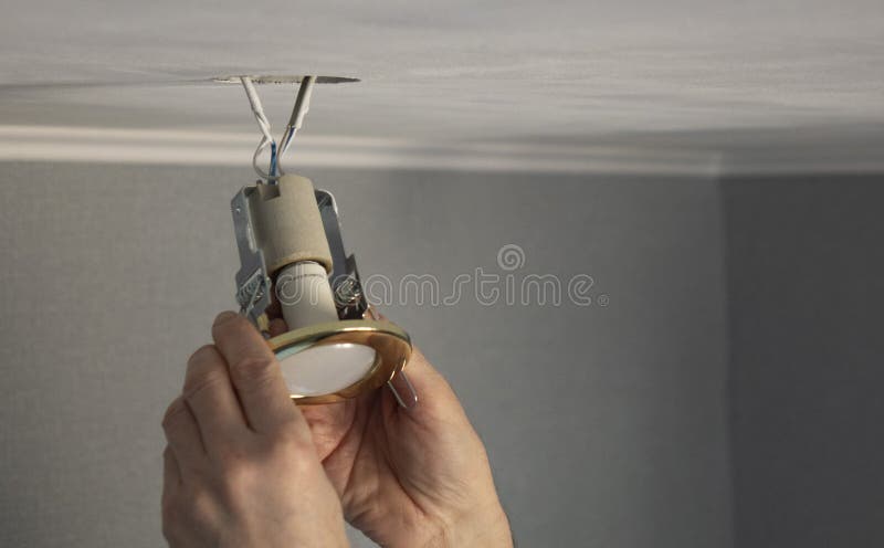 Installing Spot Light, Hand Inserts the Lamp into the Ceiling, Close-up ...