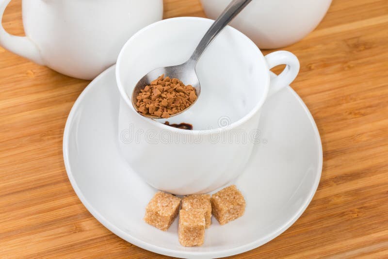 Instant Coffee Granules in Spoon Atop Empty Cup on Saucer Stock Photo ...
