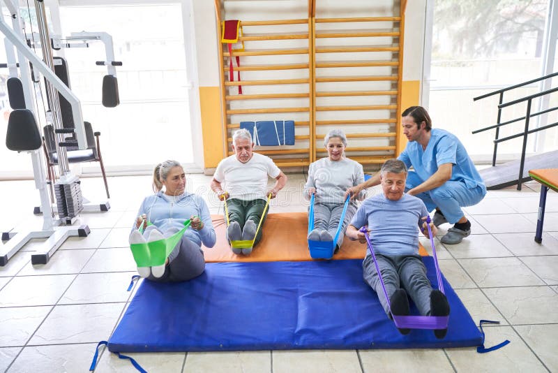 Instructor Assisting Elderly People Doing Workout in Exercise Class ...