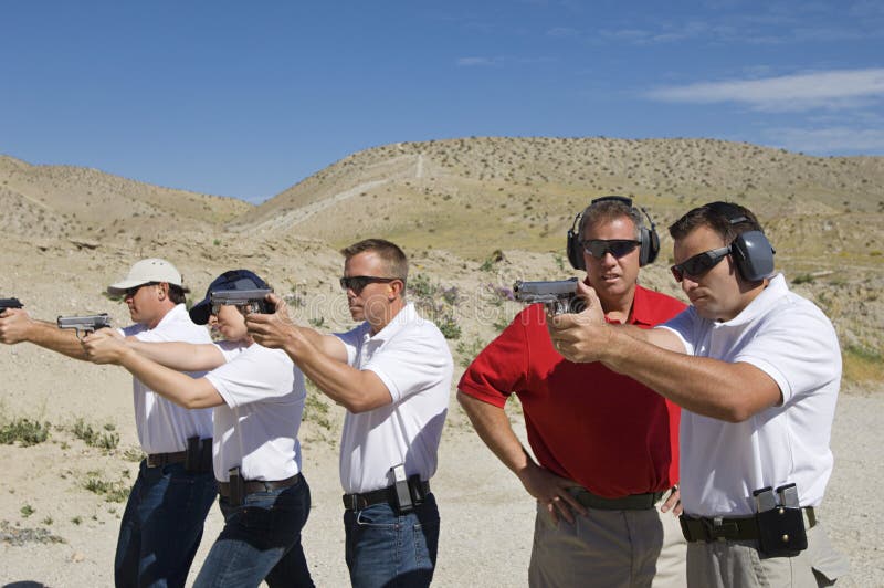 Instructor Assisting Officers at Firing Range Stock Photo - Image of ...