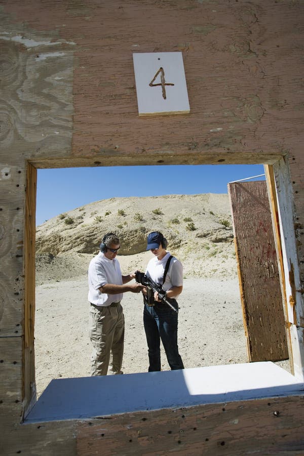 Instructor Assisting People with Guns at Firing Range Stock Photo ...