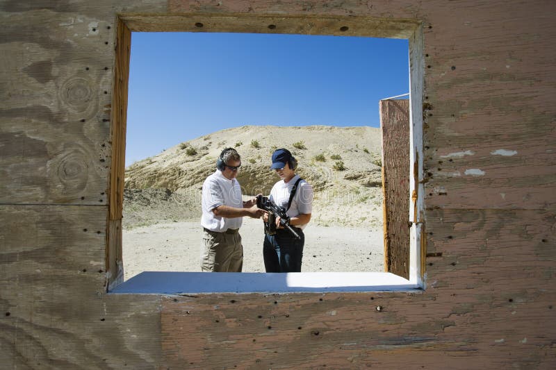 Instructor Assisting Woman at Firing Range in Desert Stock Image ...