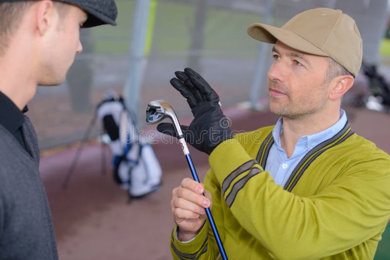 Instructor Assisting Young Man Learning Golf at Golf Course Stock Image ...