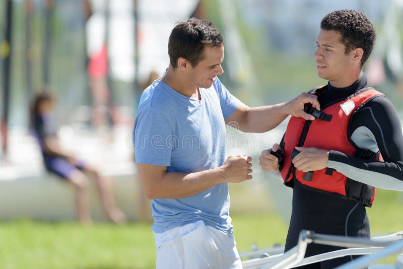 Instructor Checking Life Jacket Secure on Young Man Stock Photo - Image ...