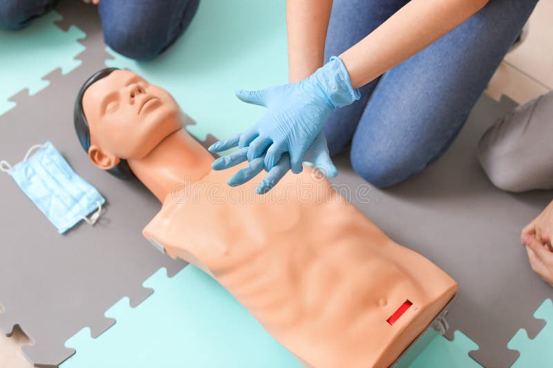Instructor Demonstrating CPR on Mannequin at First Aid Training Course ...