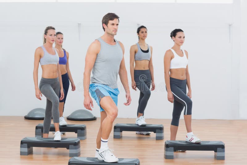 Instructor with Fitness Class Performing Step Aerobics Exercise Stock ...
