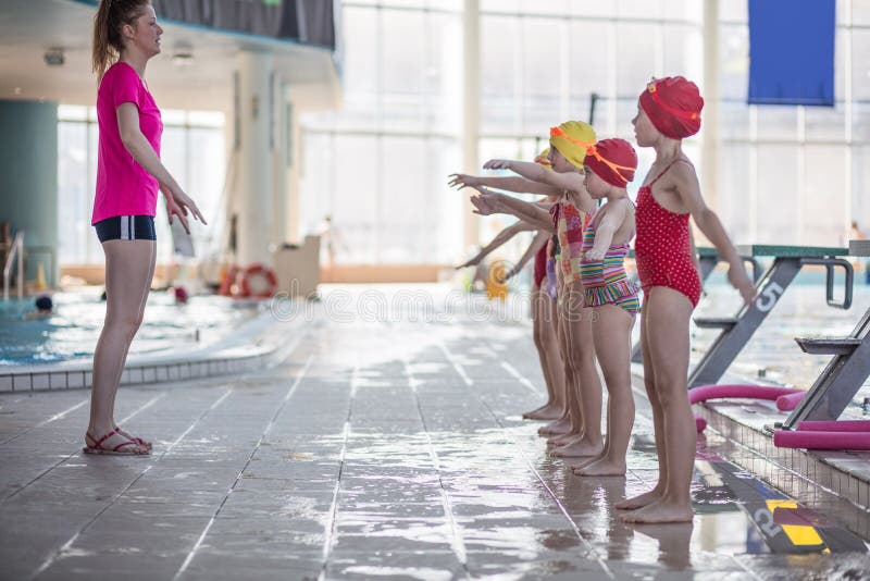 Instructor and Group of Children Doing Exercises Near a Swimming Pool ...