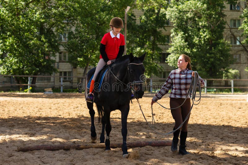 Instructor Guides Young Rider Over Obstacle during Training Stock Photo ...
