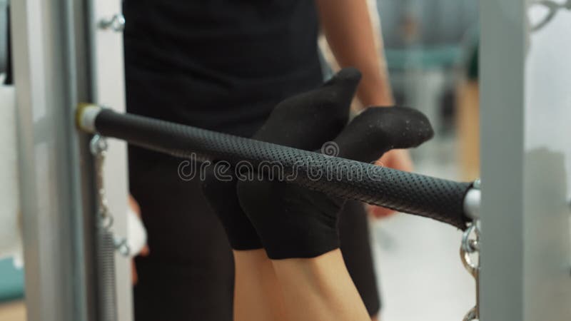 Instructor Guiding Client Foot Placement during a Reformer Exercise ...