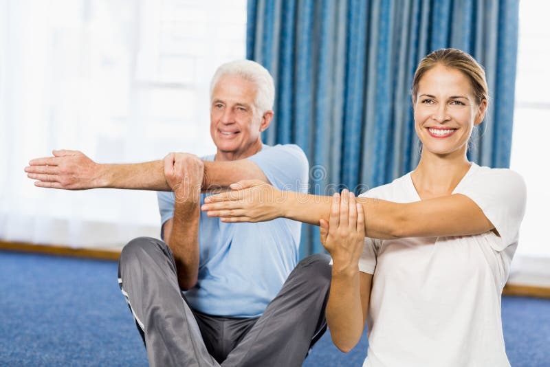 Instructor Helping Senior Man with Sport Exercises Stock Image - Image ...