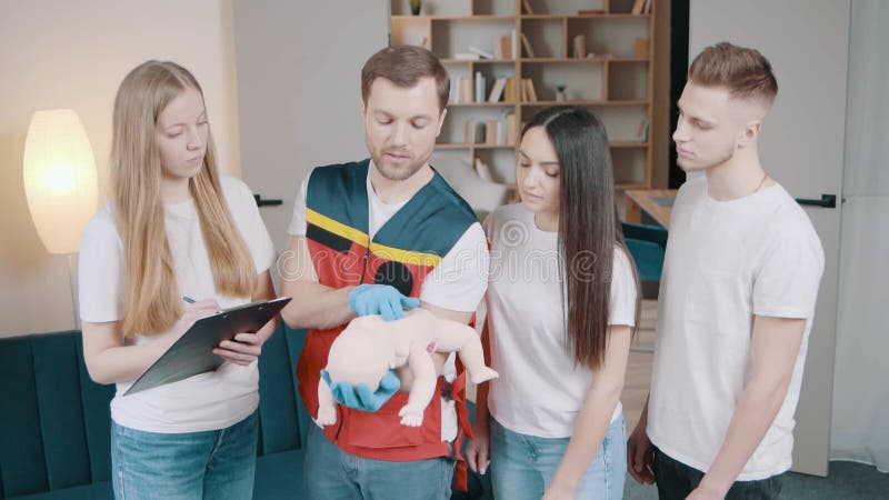 Instructor Performs CPR on Baby Training Doll. Man Instructor Show How ... Instructor Performs CPR on Baby Training Doll. Man Instructor Show How ...