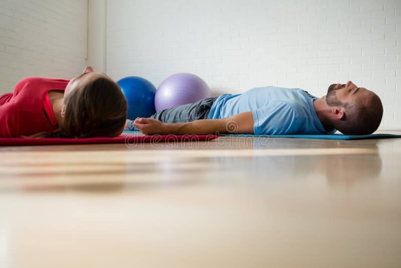 Instructor and Student Exercising while Lying on Mat in Studio Stock ...