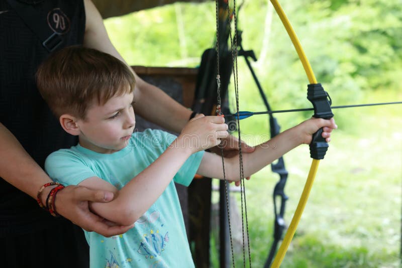 Instructor Teaching Boy To Shoot Bow Stock Photo - Image of instructor ...