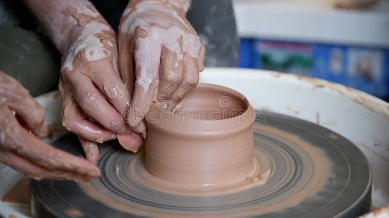 An Instructor Teaching a Student How To Smoothing Pottery Clay Using ...