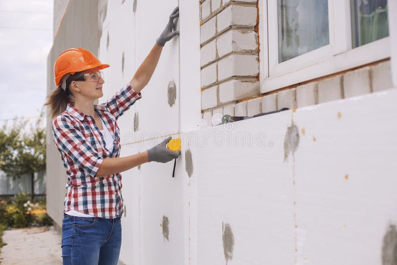 Insulation of the House with Polyfoam. the Worker is Checking with the ...