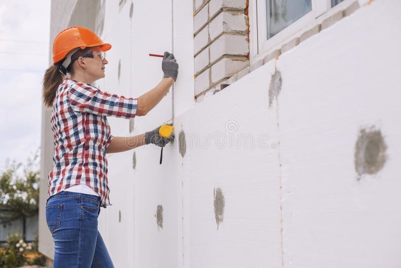 Insulation of the House with Polyfoam. the Worker is Checking with the ...
